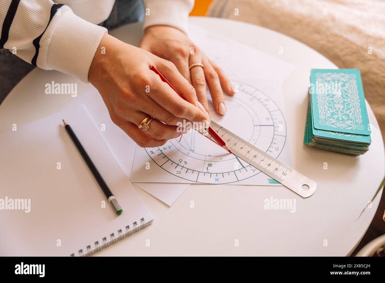 Woman drawing with pencil and ruler on natal chart Stock Photo - Alamy