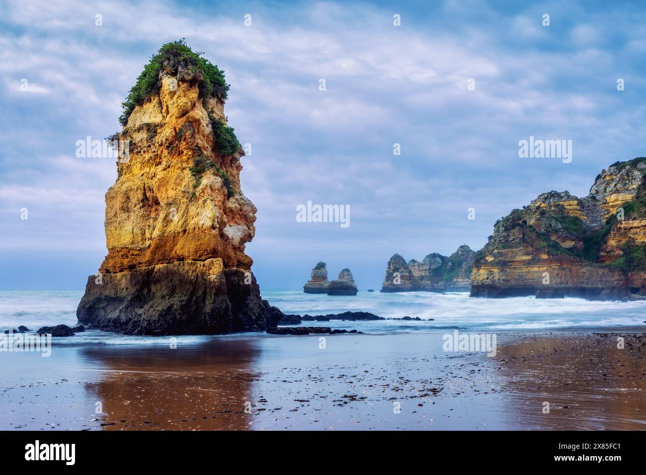Early morning at Praia Dona Ana beach, with its spectacular sea stacks ...