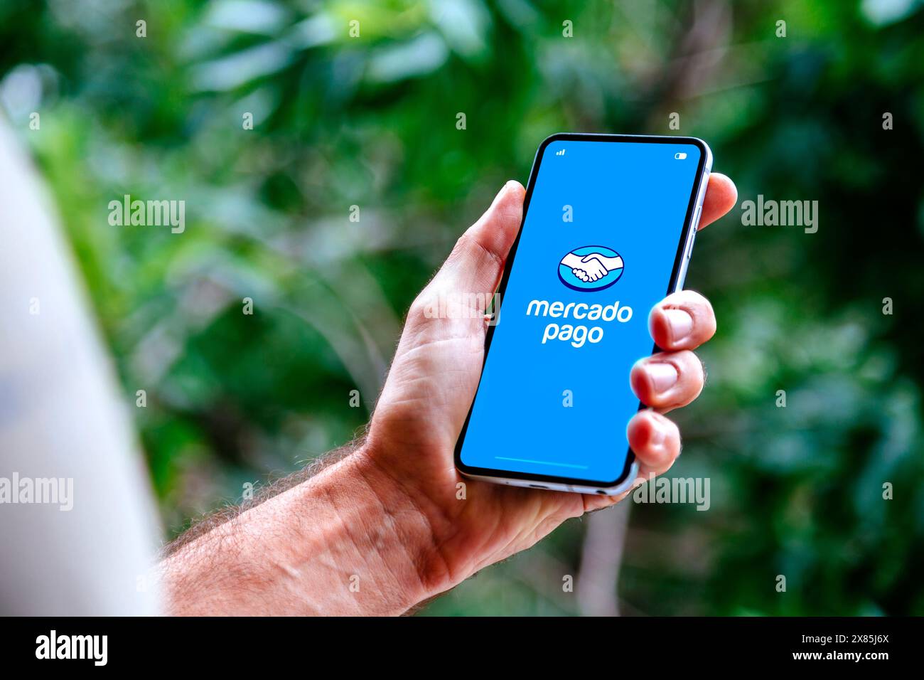 Man holding a smartphone with Mercado Pago app on the screen. Rosario ...