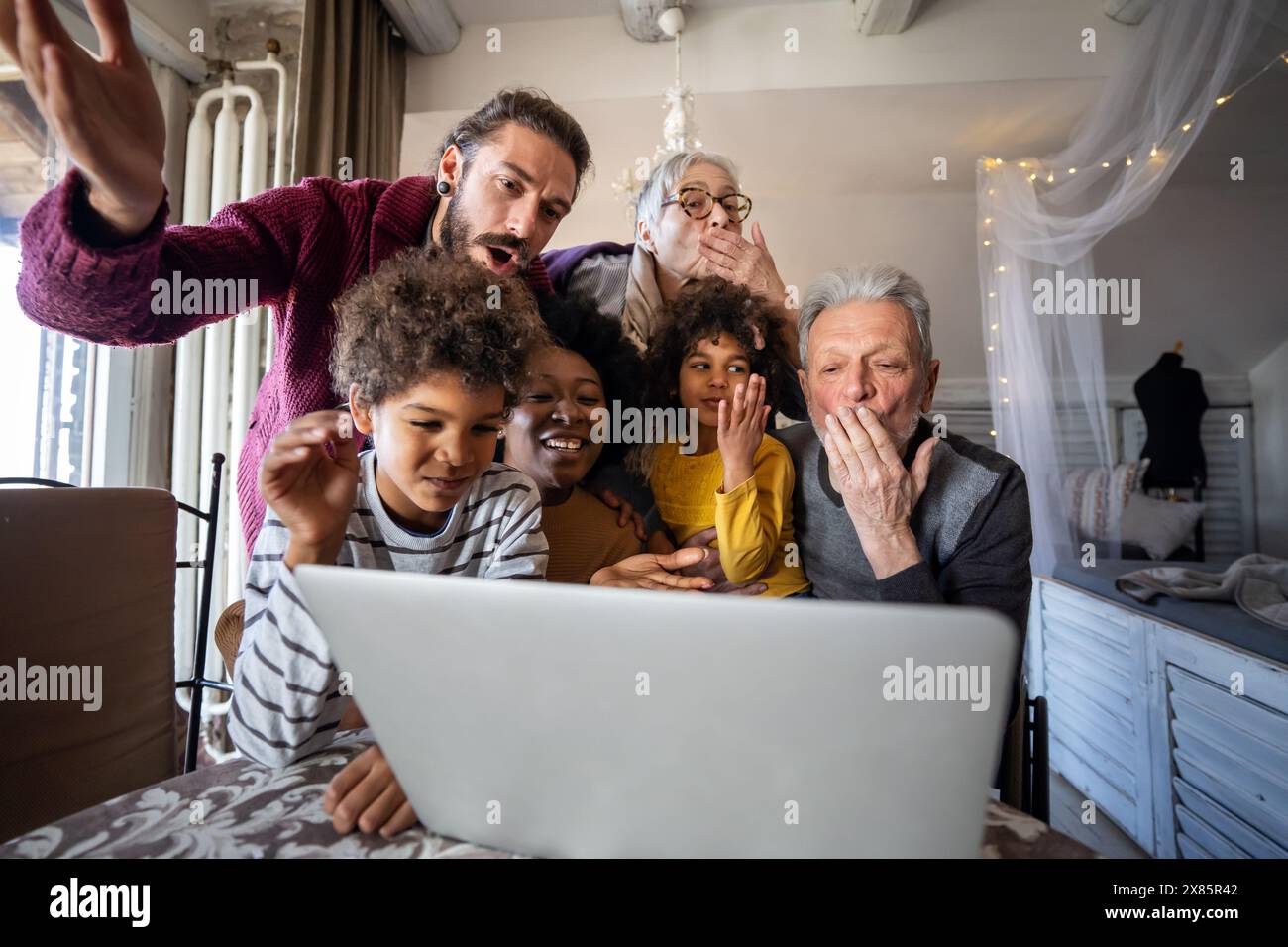 Extended multiethnic family together at home during video call. People ...