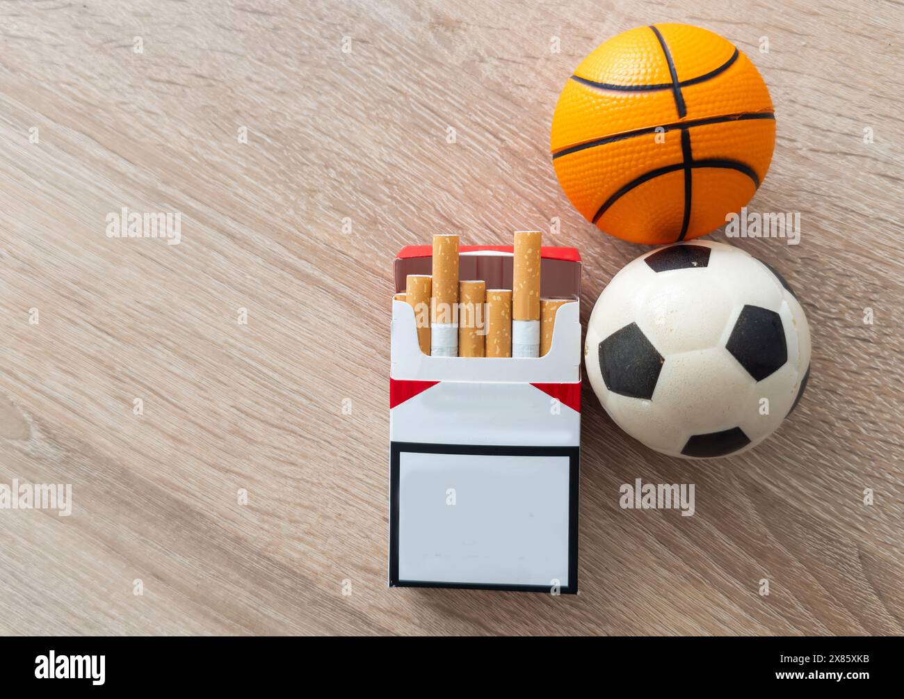 Smoking or sports. Sport ball and pack of cigarettes on table ...