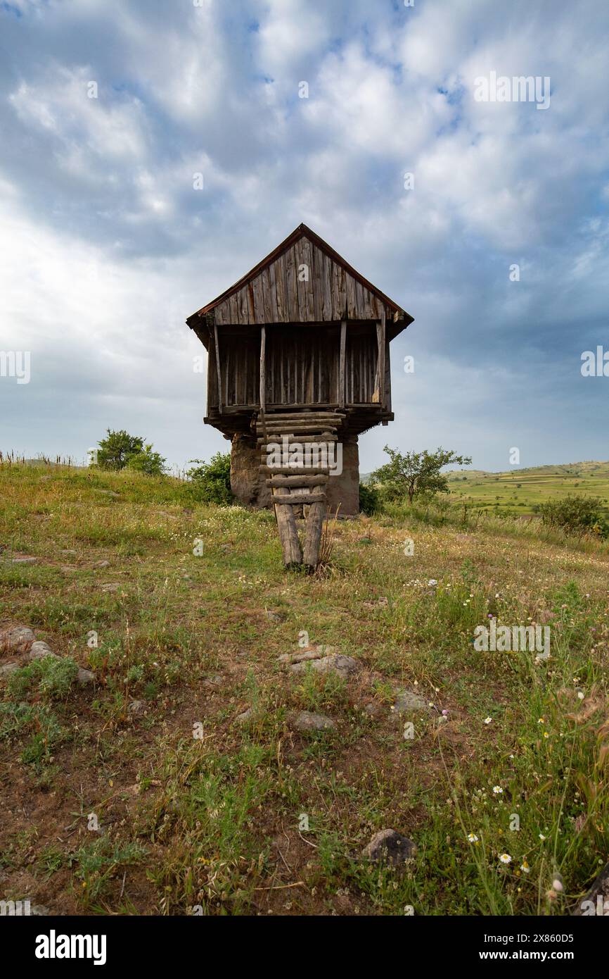 A wind mill from 19th century remains standing in a countryside and seems like an wooden house ...
