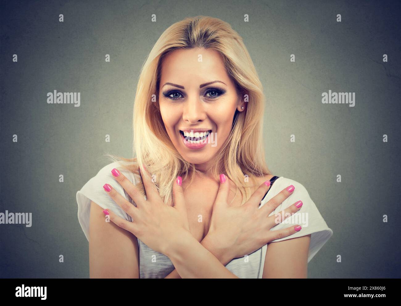 Surprised young woman smiling in studio Stock Photo - Alamy
