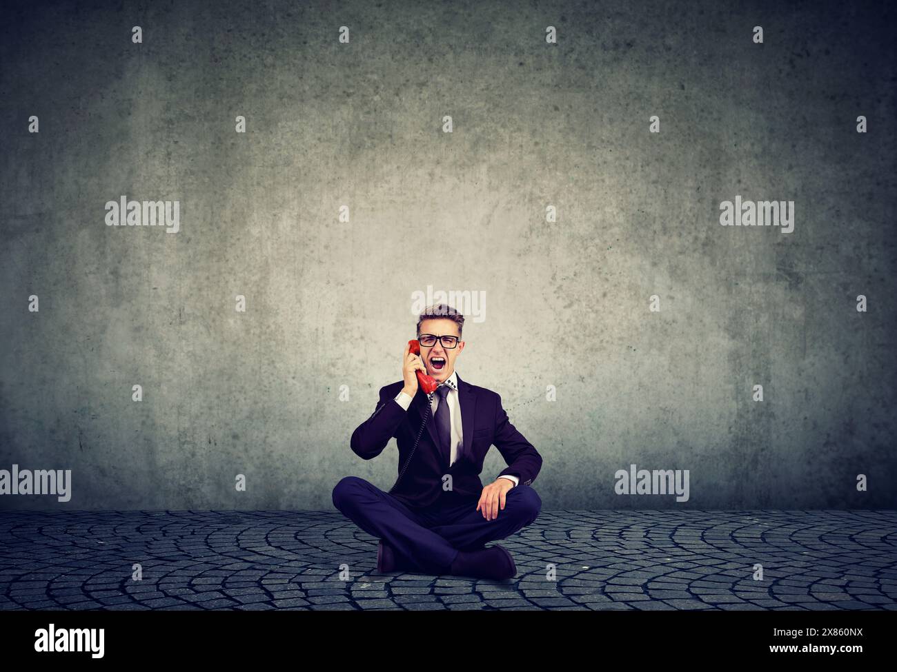 Angry business man sitting on the floor and shouting on the phone Stock ...