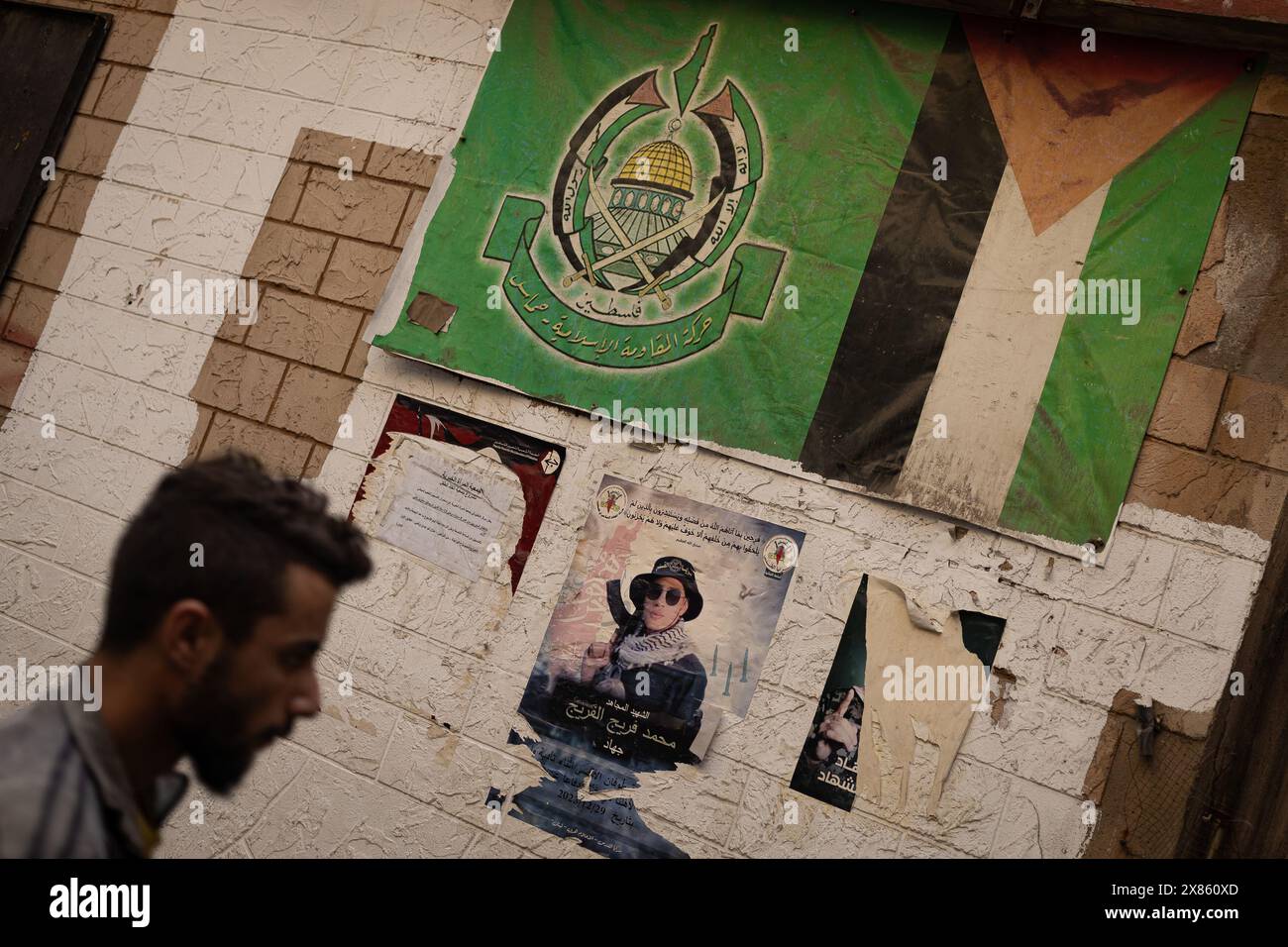 Beirut, Lebanon. 18th May, 2024. A man walks by posters depicting the ...