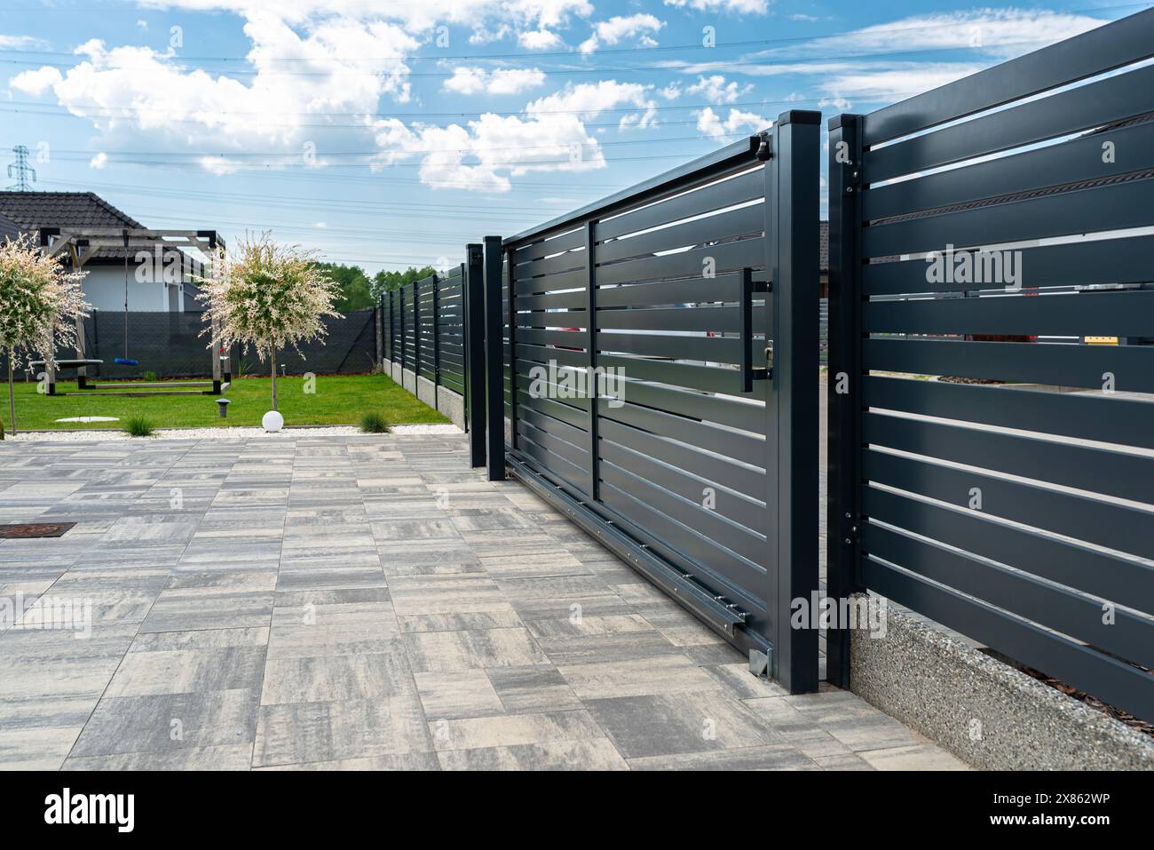 A modern panel fence in anthracite color, visible sliding gate to the ...