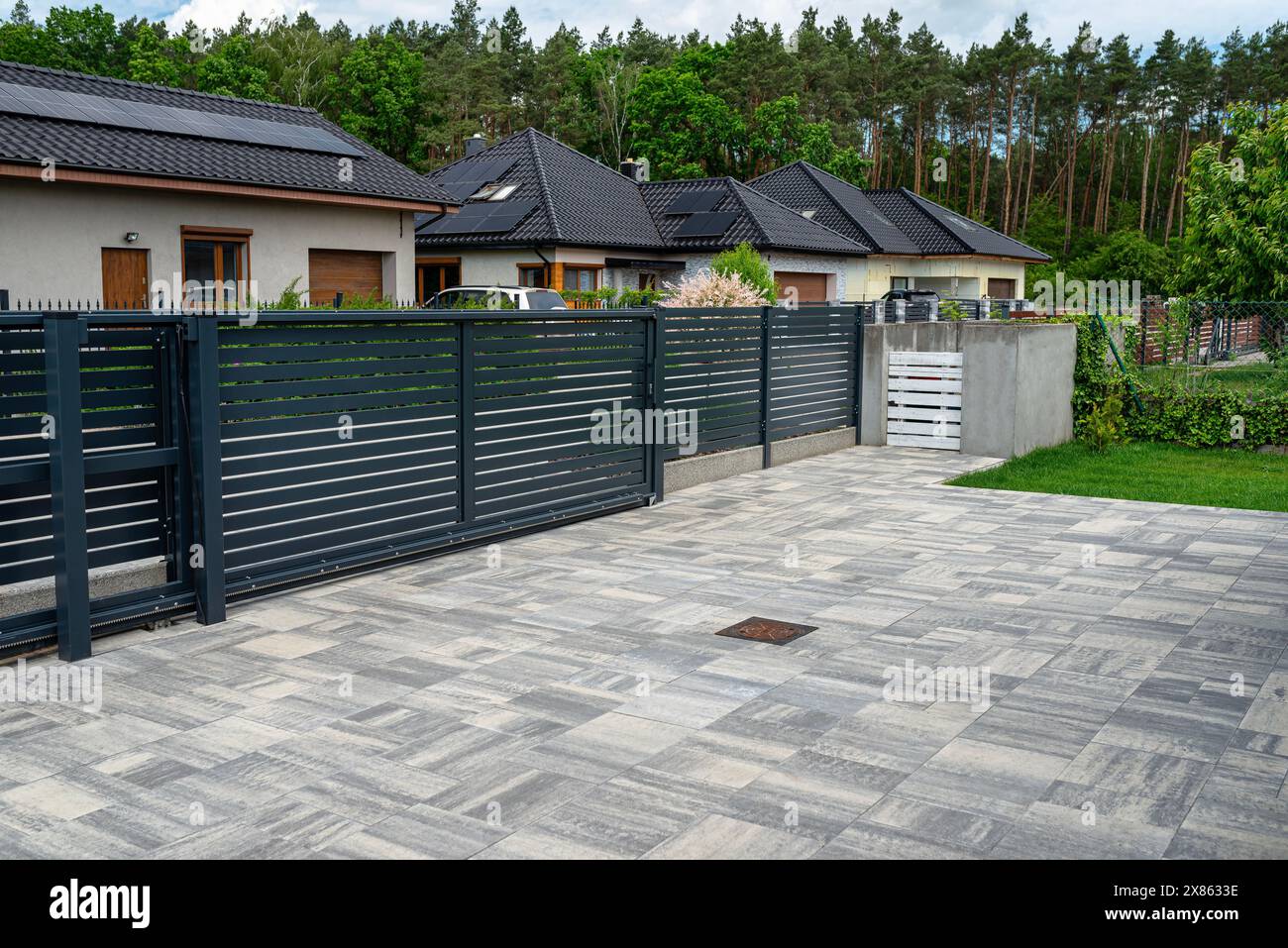 A modern panel fence in anthracite color, visible sliding gate to the ...