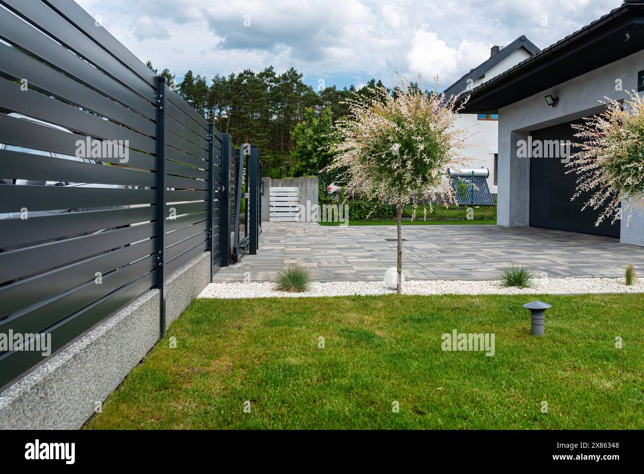 A modern panel fence in anthracite color, visible sliding gate to the ...