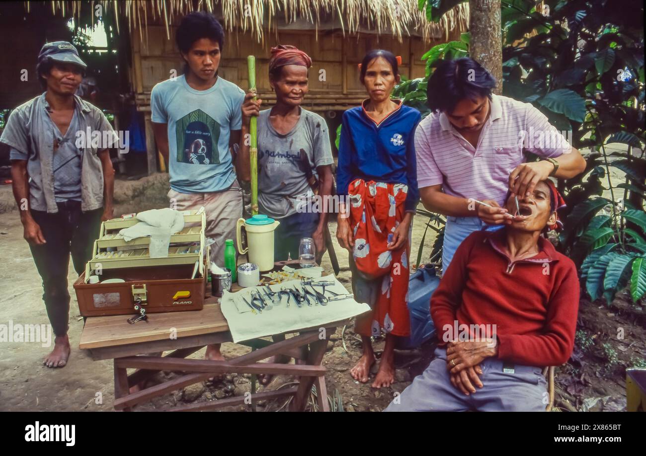 Philippines, Mindenao; Mobile dentist at work in a village and pulling ...