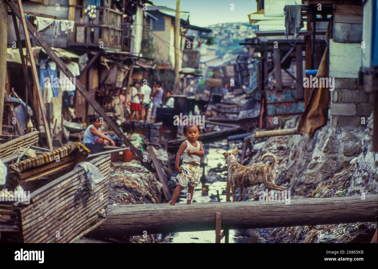 Philippines, Manila; Little boy over an open sewer of the slum he lives in Stock Photo - Alamy