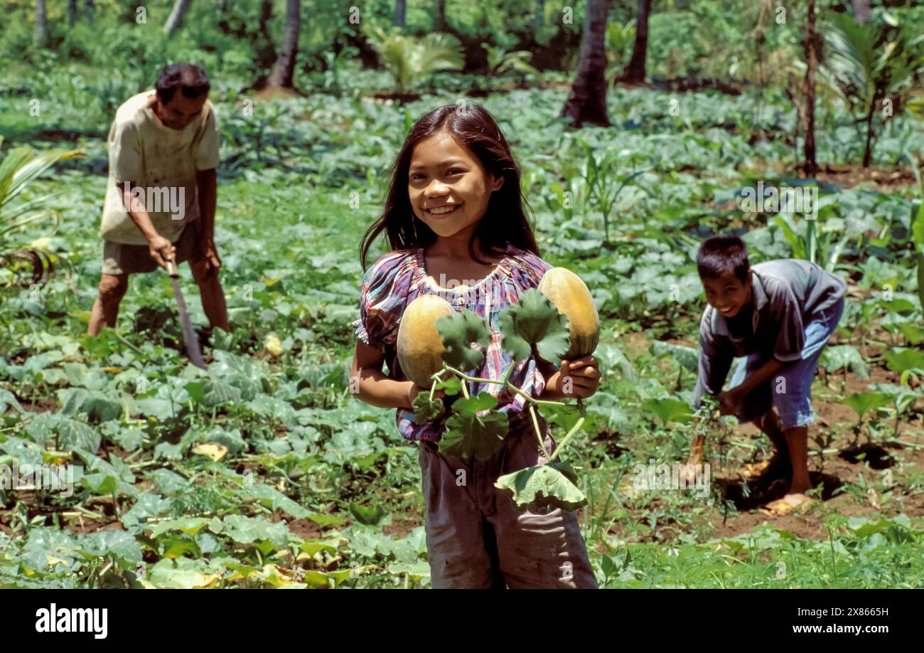 Philippines, Mindanao, Kilate; Portrait of a girl holding gourds ...