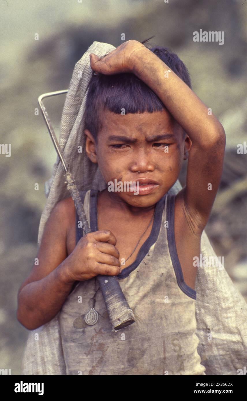 Philippines, Manila; Boy collects plastic and glass on the 'Smokey ...