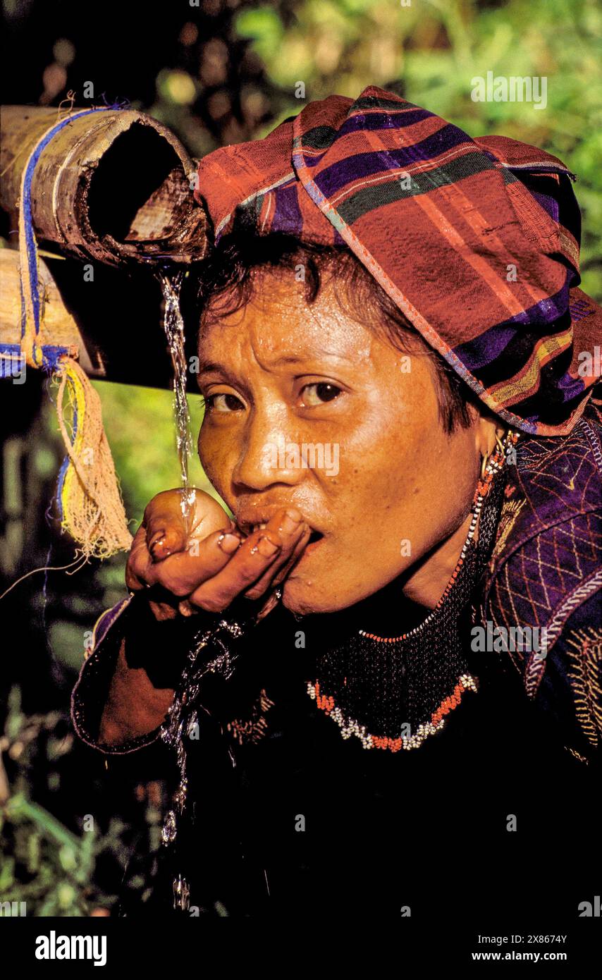 Philippines, Mindanao; Woman of the T'boli tribe drinking water from a ...