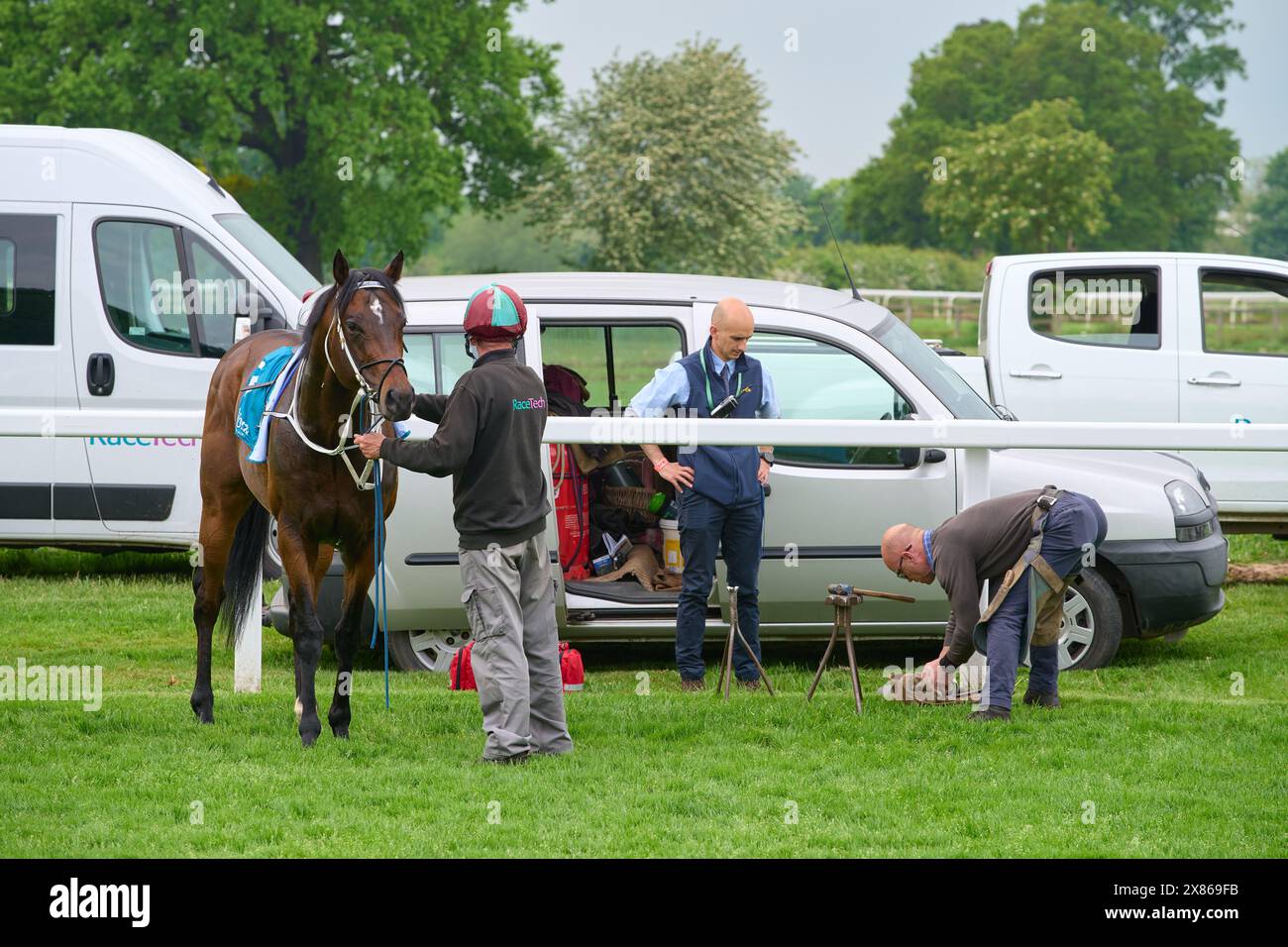Racecourse staff repairing a horseshoe trackside before the start of a ...