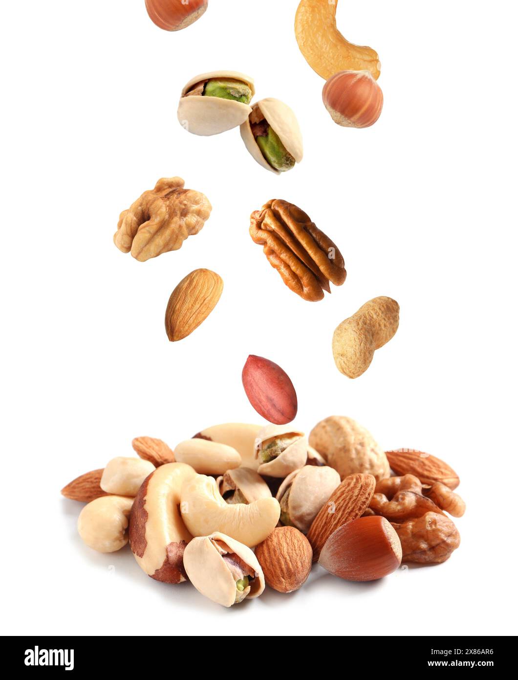 Mix of different nuts falling on white background Stock Photo - Alamy