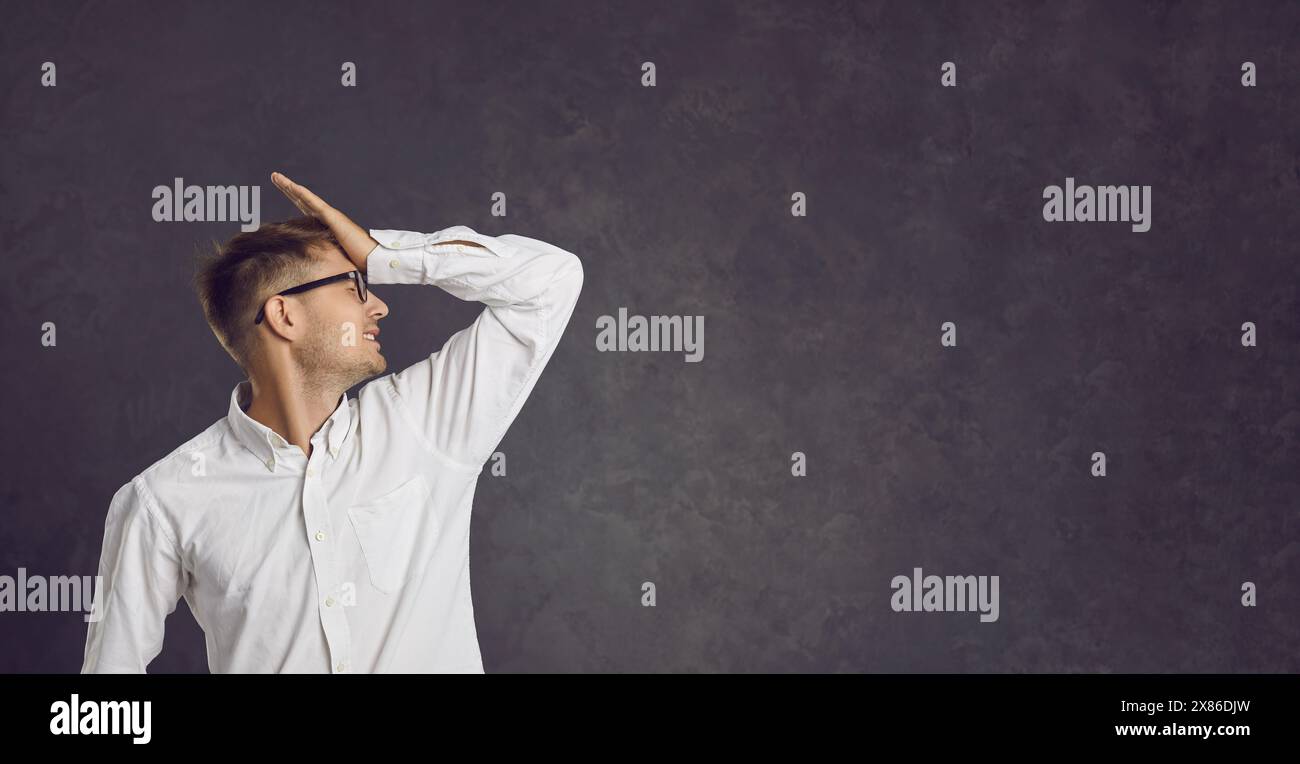 Embarrassed man keeps his hand on his forehead remembering that he ...