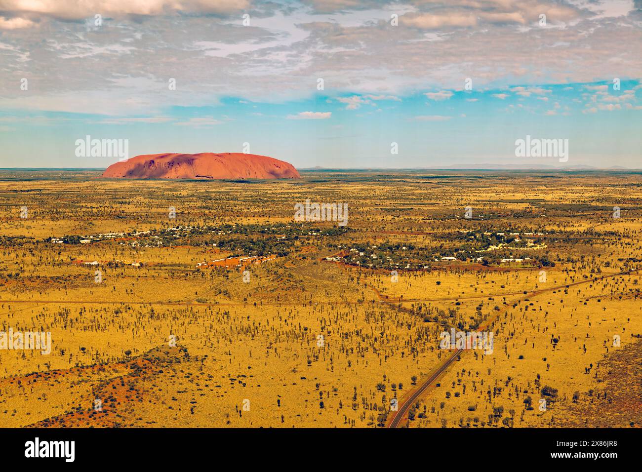 Aerial view of the town of Yulara with Uluru in the background Stock ...
