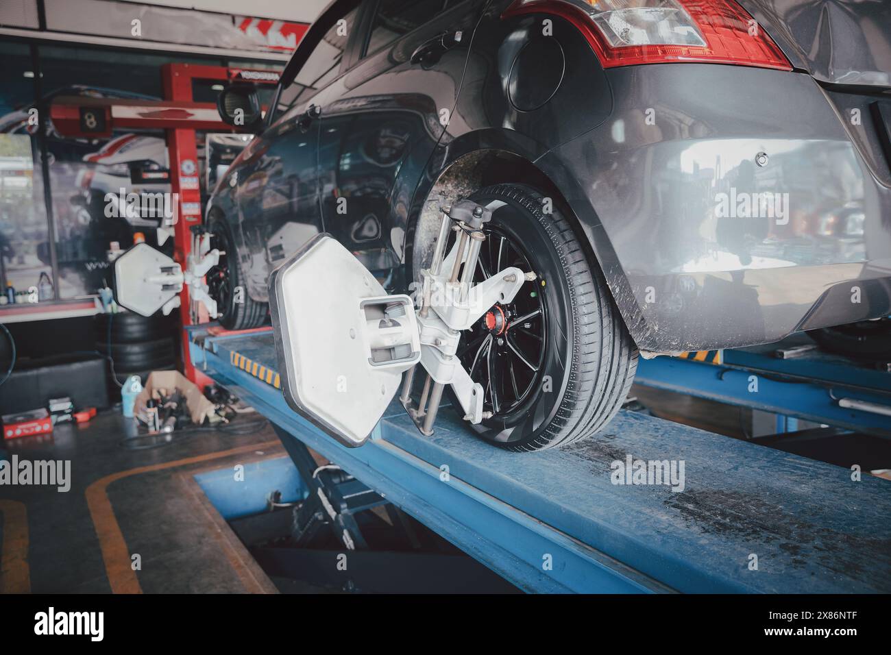 Car wheel balancer calibrate with laser reflector attach on each tire ...