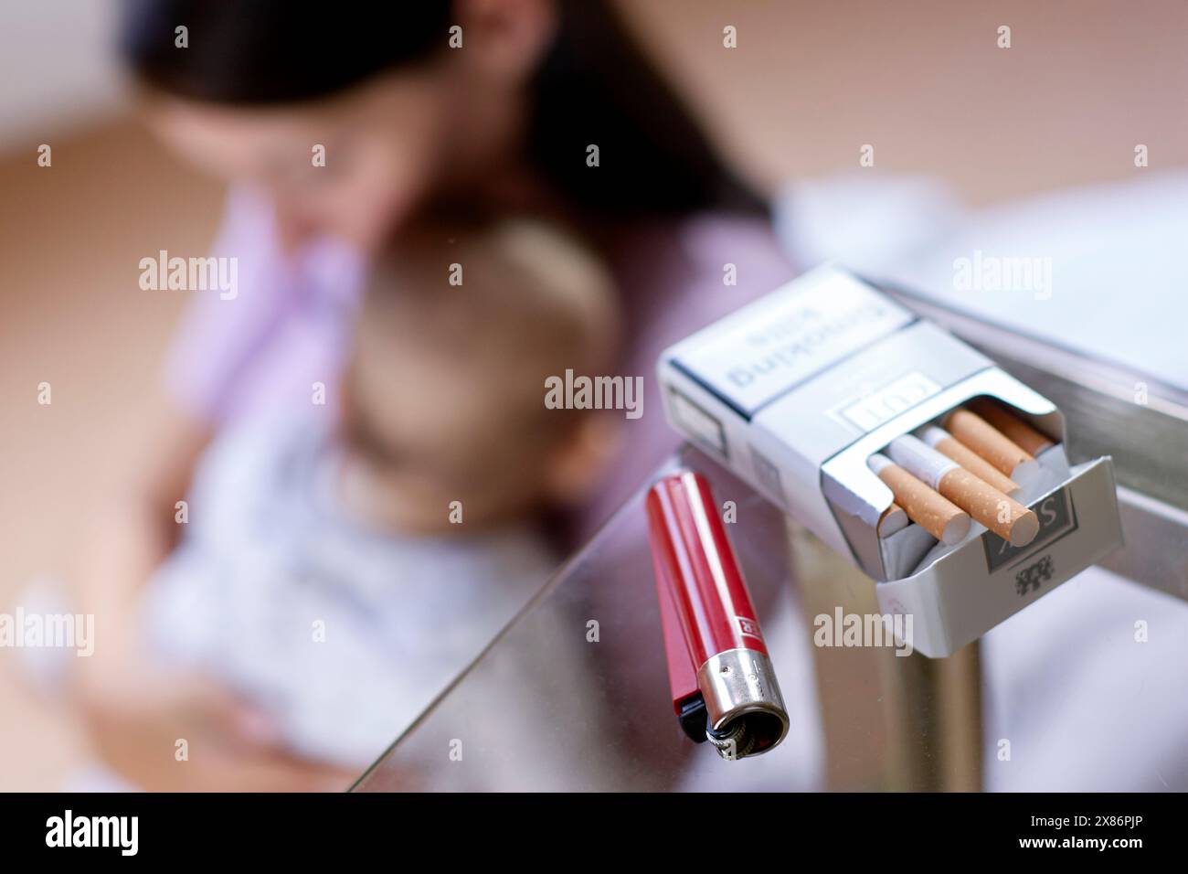 Woman smoking next to newborn baby Stock Photo - Alamy