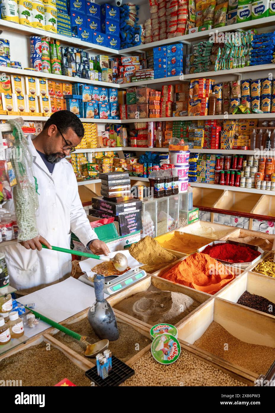 Er-Rich, Morocco - 7 March, 2024: Moroccan shopkeeper mixing spices in ...