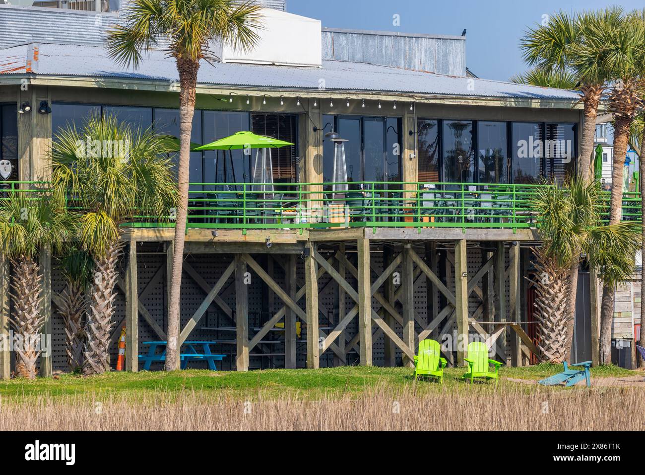 Backside of a building exterior where colorful chairs, tables and ...