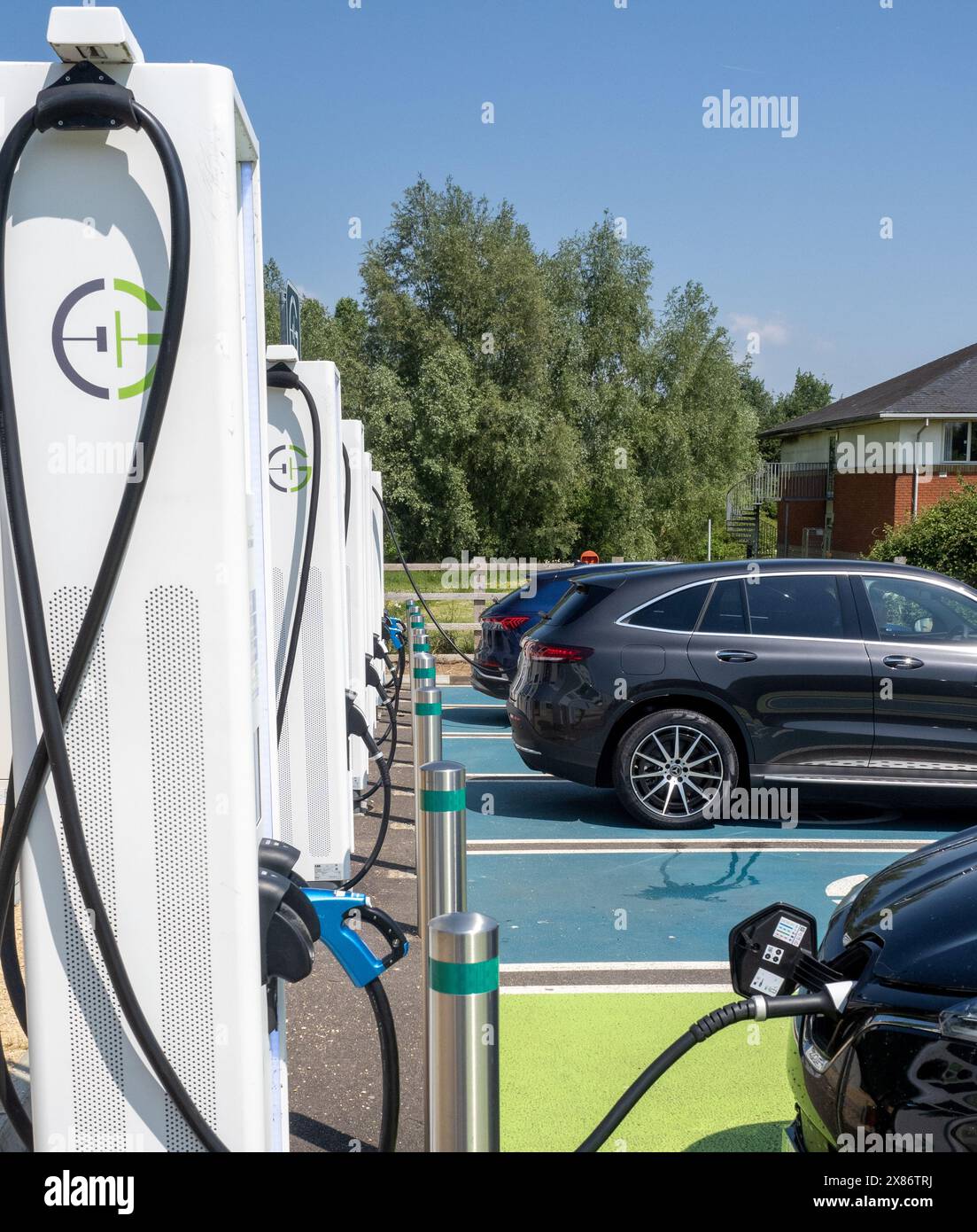 Electric Cars charging at charging points at a motorway service station on a hot sunny day Stock ...