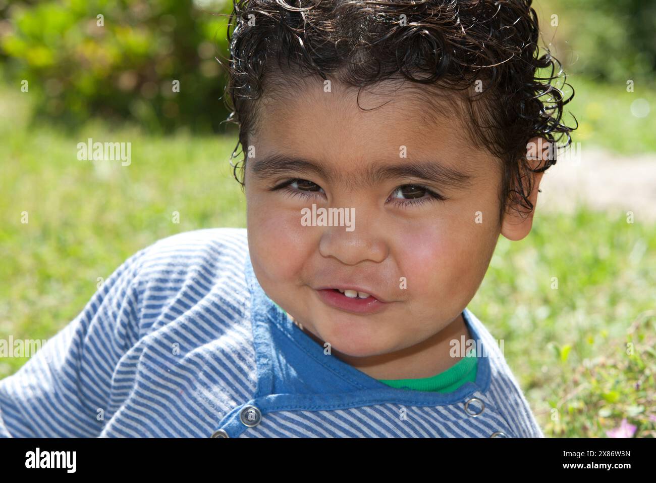 portrait of a adorable hispanic little boy making funny face outdoors ...