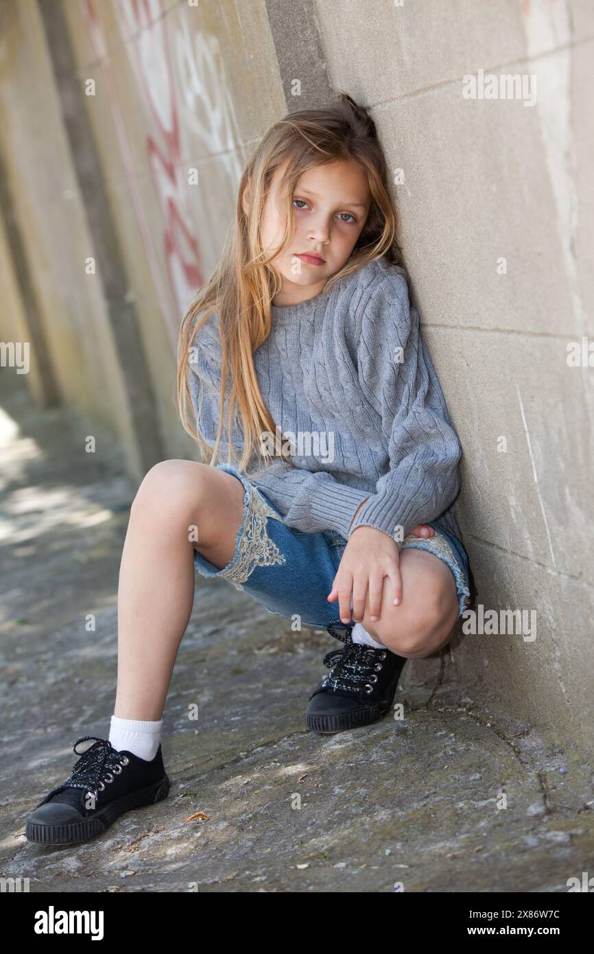 Depressed Girl Sitting Against Wall