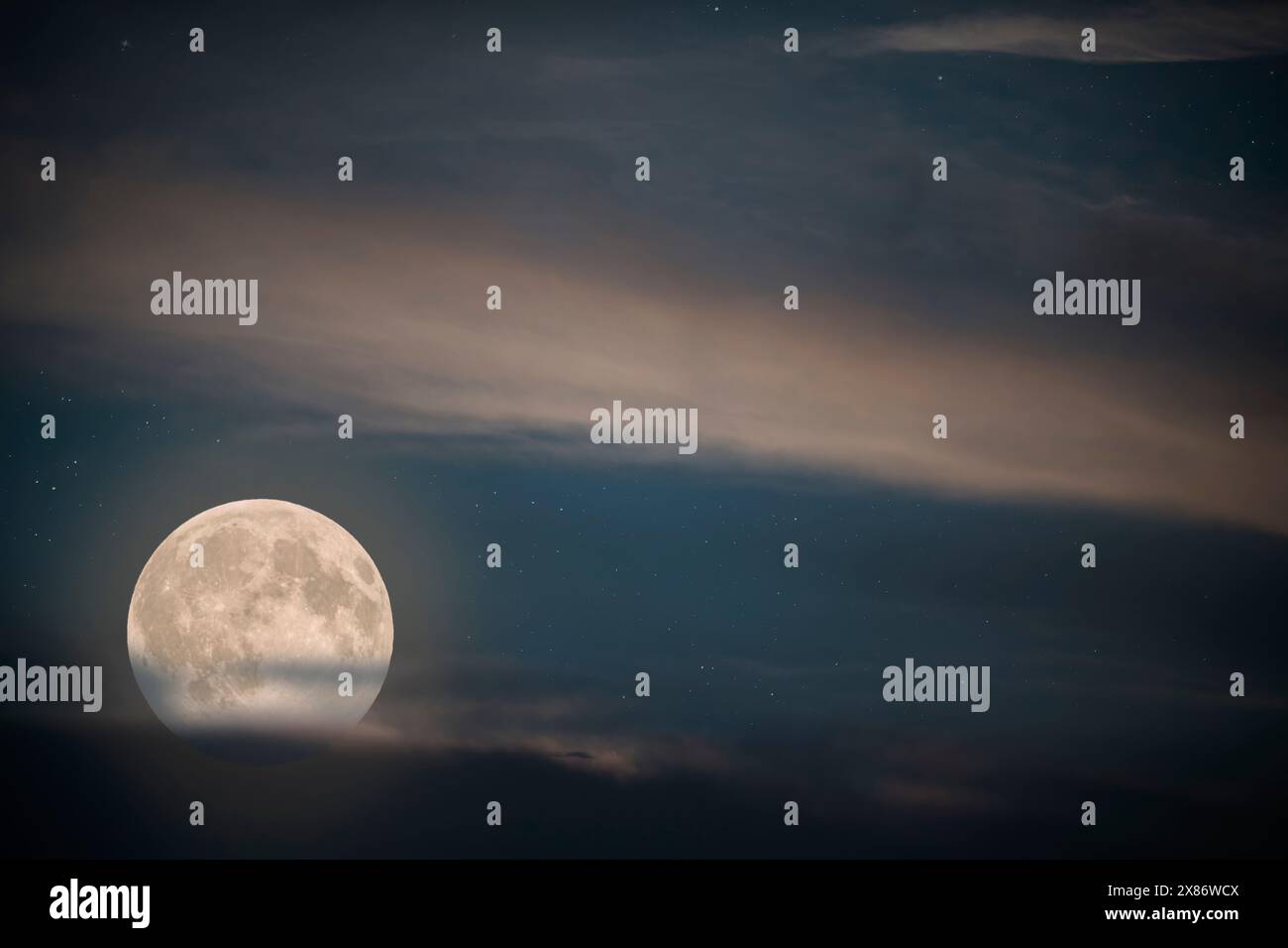 Rising full moon in a cloudy but starry night Stock Photo - Alamy