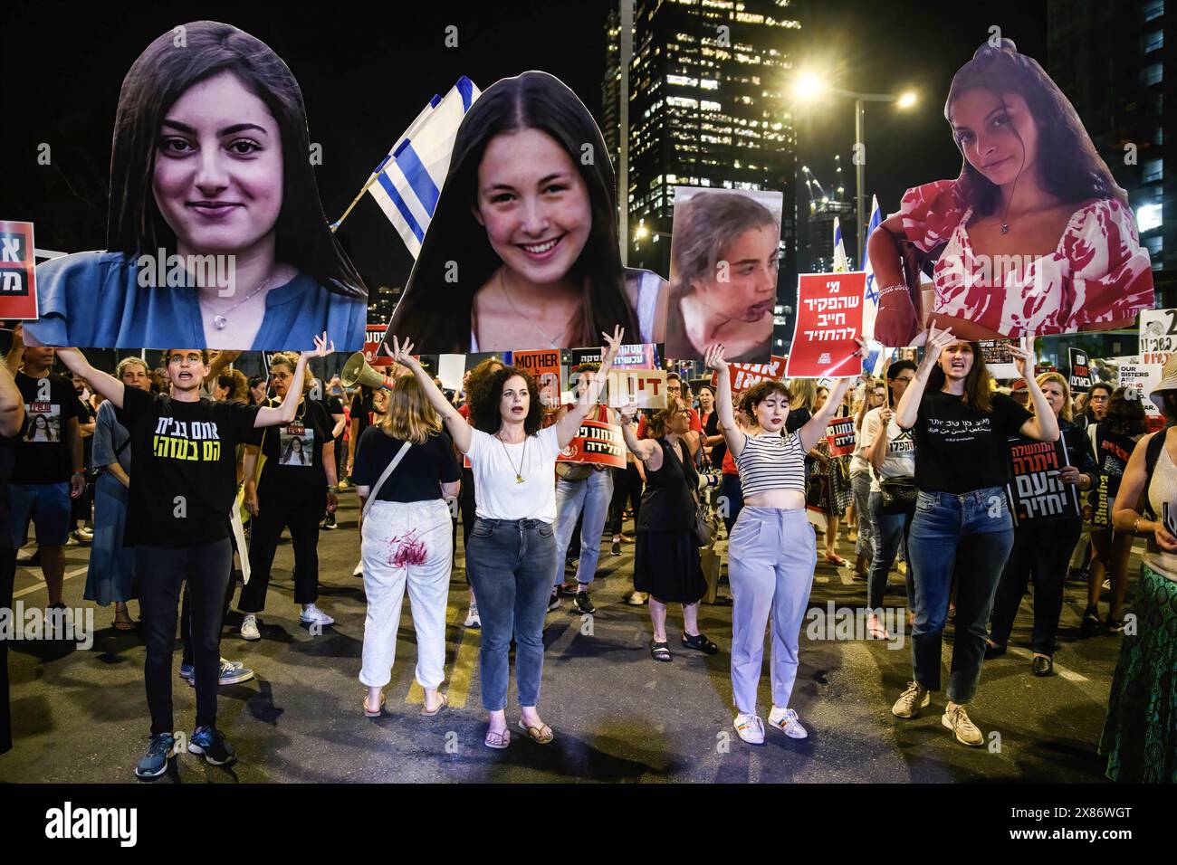 Female protestors hold up signs with photos of IDF female hostage ...