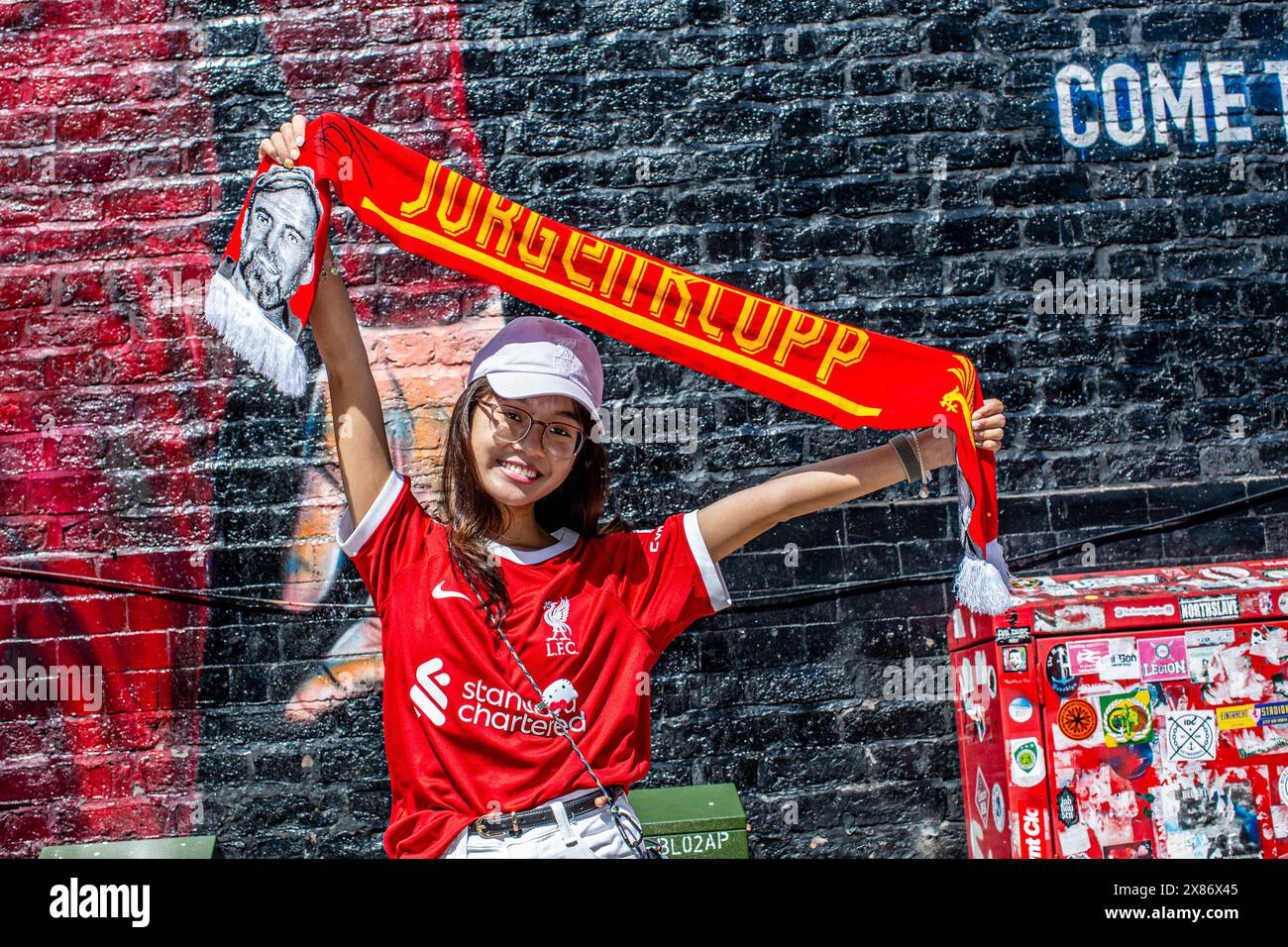 Asian female supporter holding a Jurgen Klopp scarf in fron of mural in ...