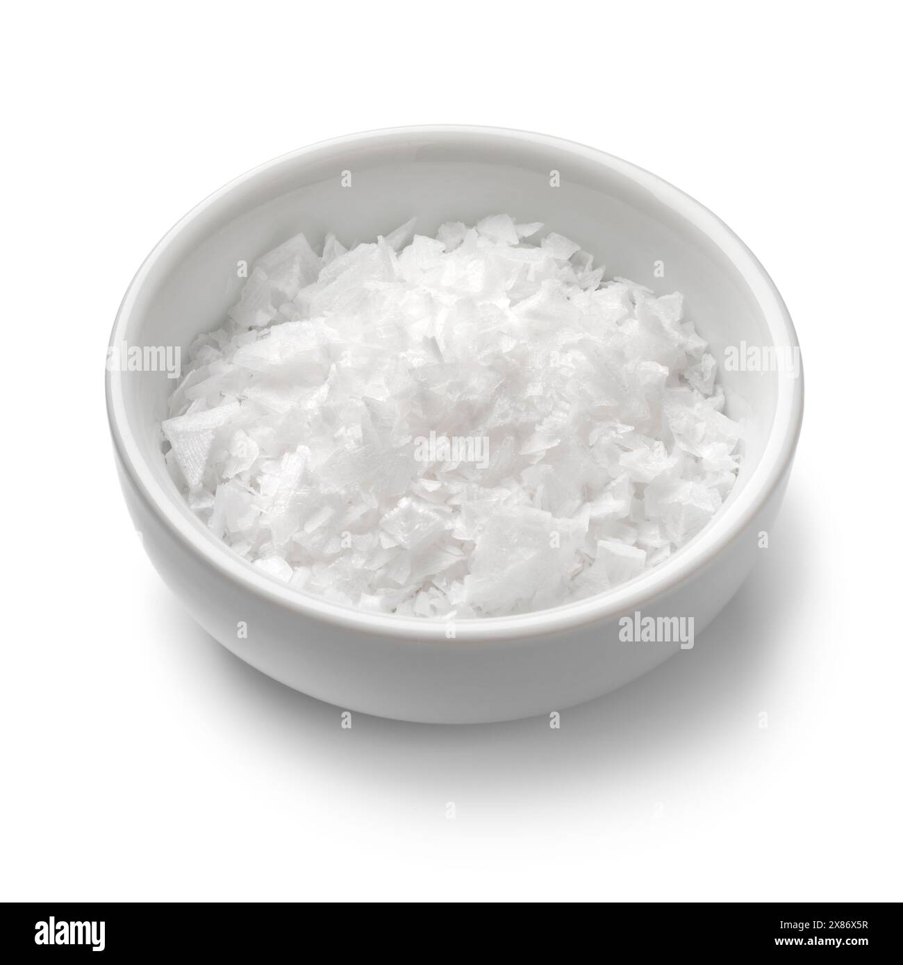 Single bowl with white sea salt flakes isolated on white background ...