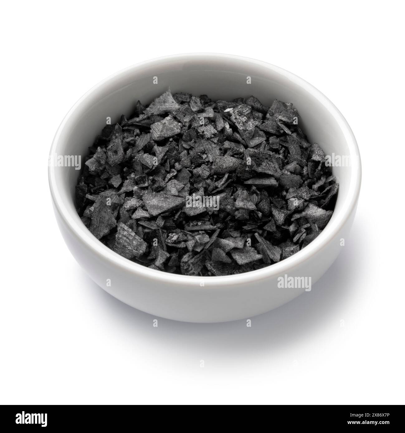 Single white bowl with black sea salt flakes isolated on white ...