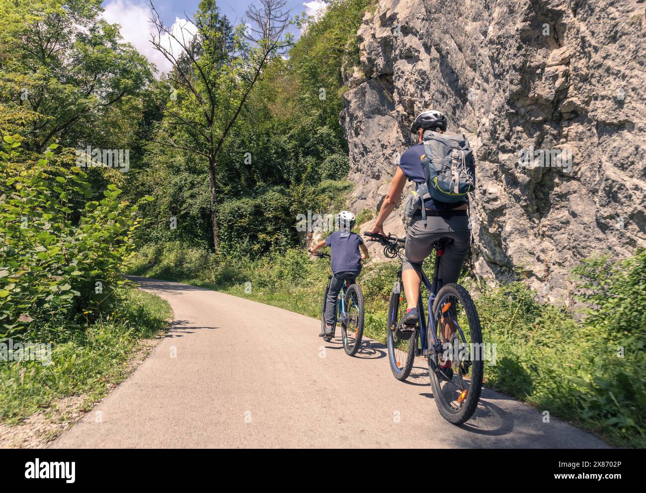 Mother and young son riding bikes along a scenic rural landscape ...