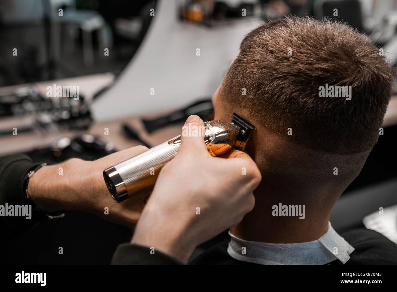 Hairdresser shaves the clients hair on the temple in the stylish ...
