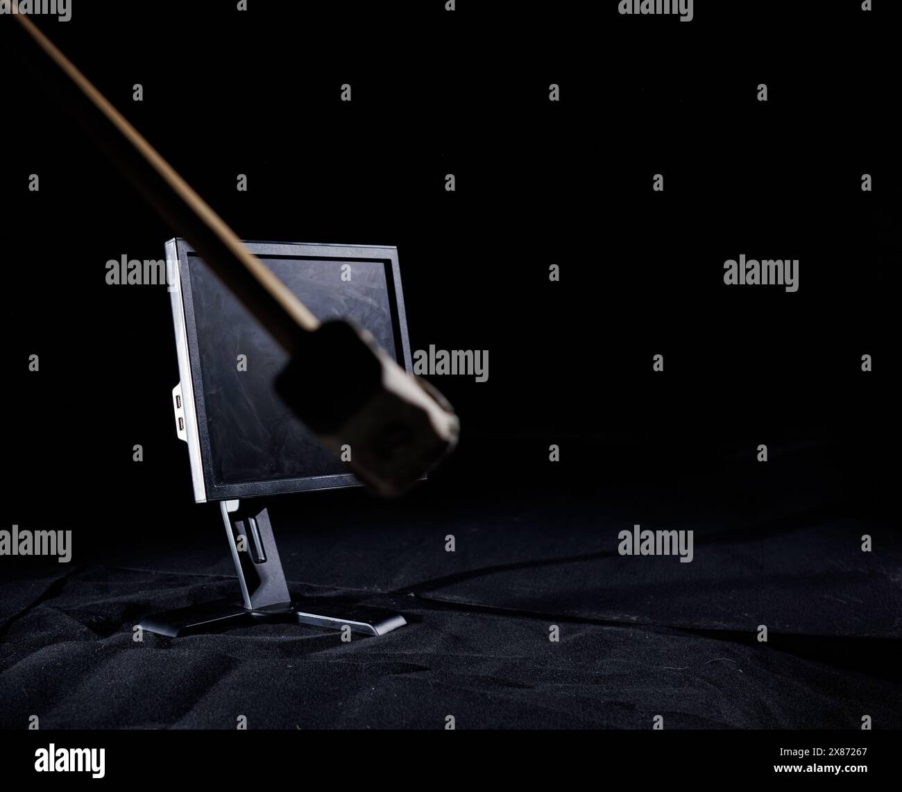 Blow of a big hammer to a computer monitor, isolated on a black ...