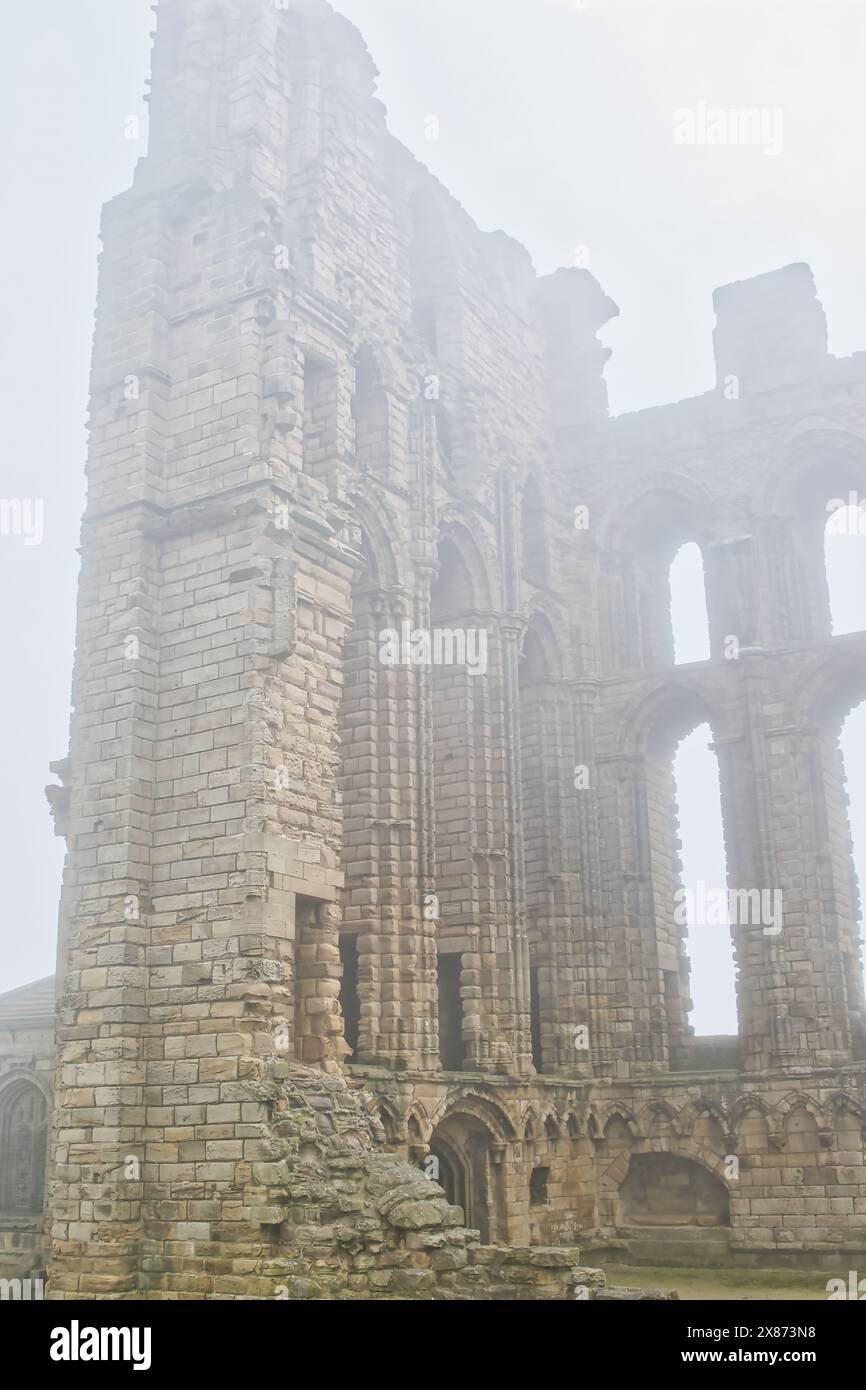 A misty view of an ancient stone castle ruin with tall, weathered walls ...