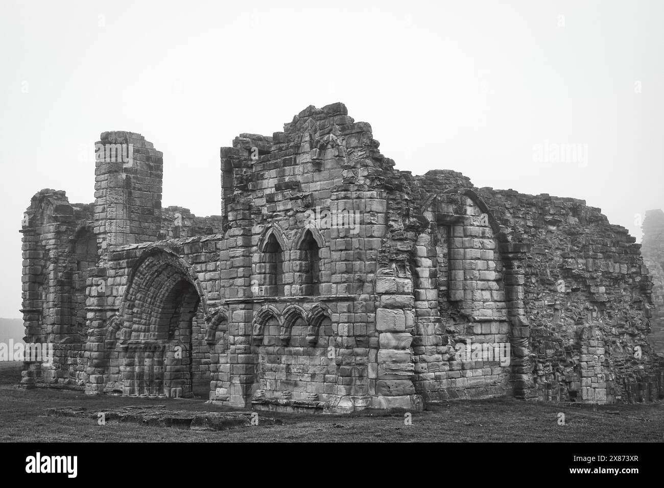 A black and white photograph of an ancient stone ruin with arched ...