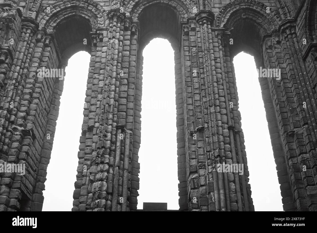 Black and white photo of ancient stone arches with tall, narrow windows ...