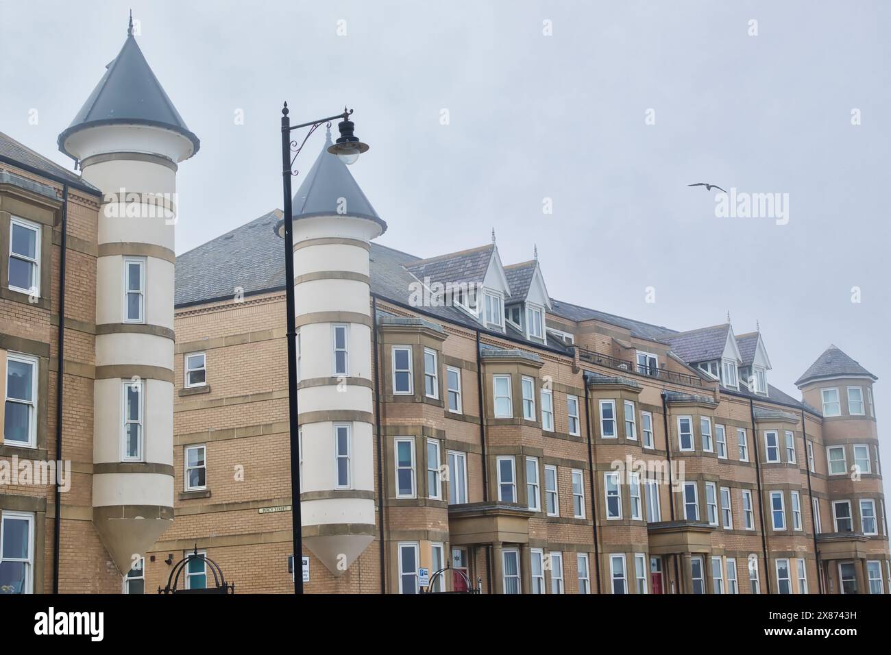 A row of modern brick buildings with unique cylindrical towers and ...