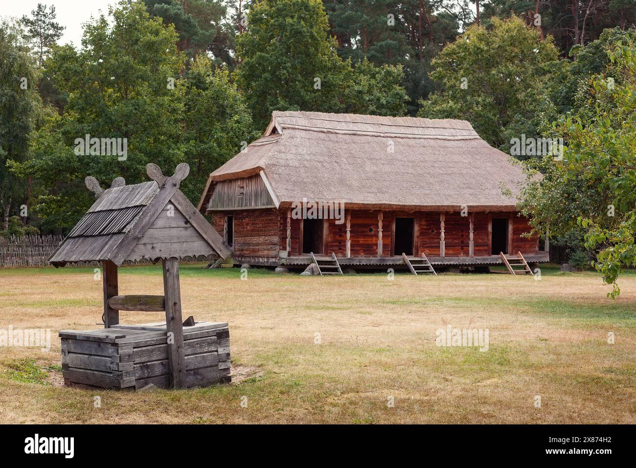 The courtyard of an ancient Lithuanian homestead with a wooden well and ...