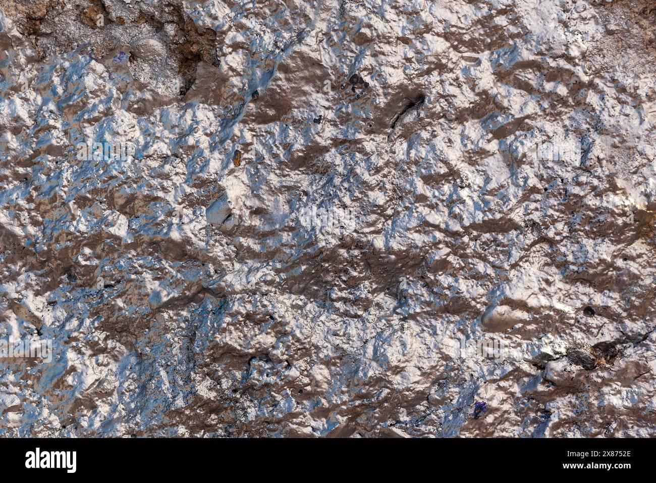 The rough and wrinkled concrete wall is painted with rose silver ...