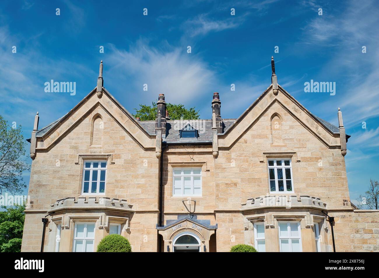 A historic stone building with a symmetrical facade, featuring pointed ...