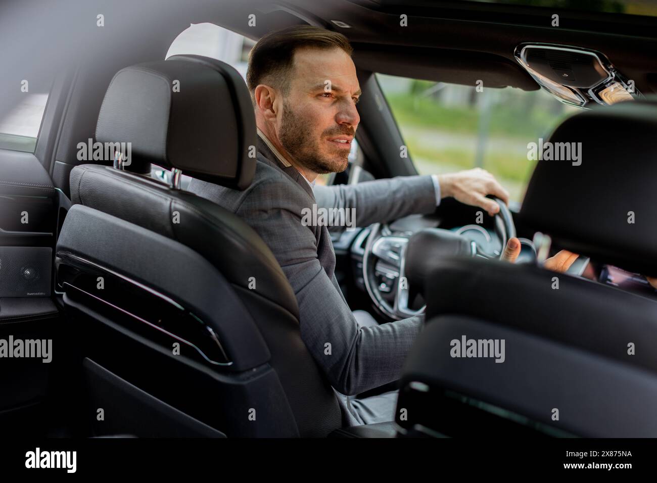An angry man in a suit yelling while behind the wheel in gridlocked ...