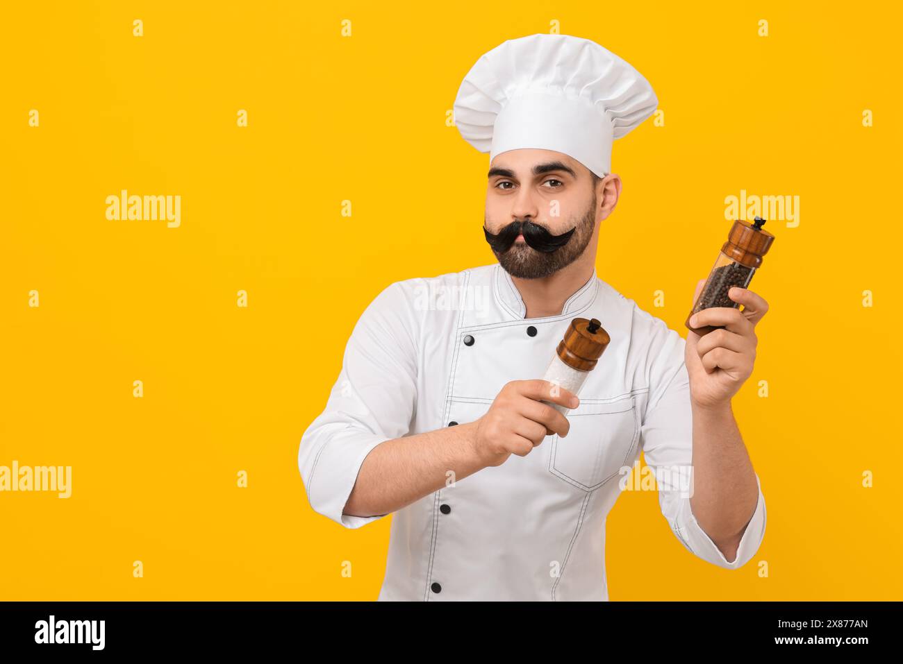 Professional chef with funny artificial moustache holding shakers on ...