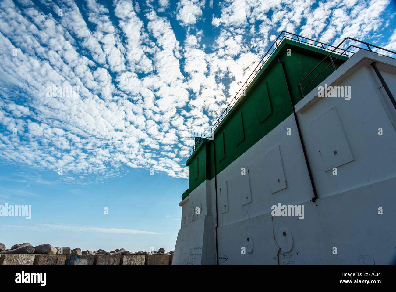 green lighthouse of Malamocco harbor inlet with concrete breakwaters ...