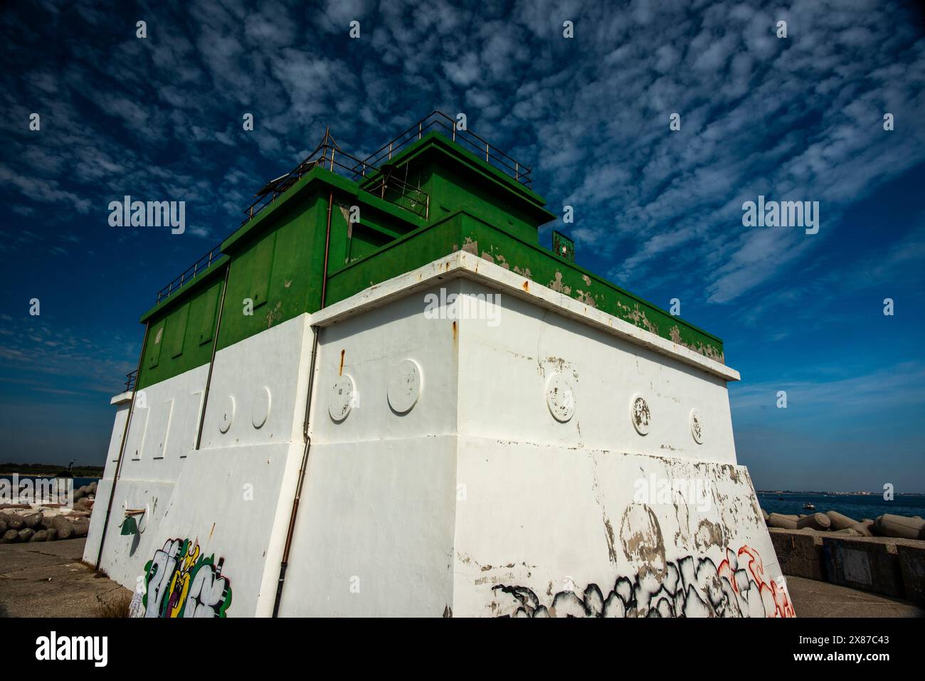 green lighthouse of Malamocco harbor inlet with concrete breakwaters ...