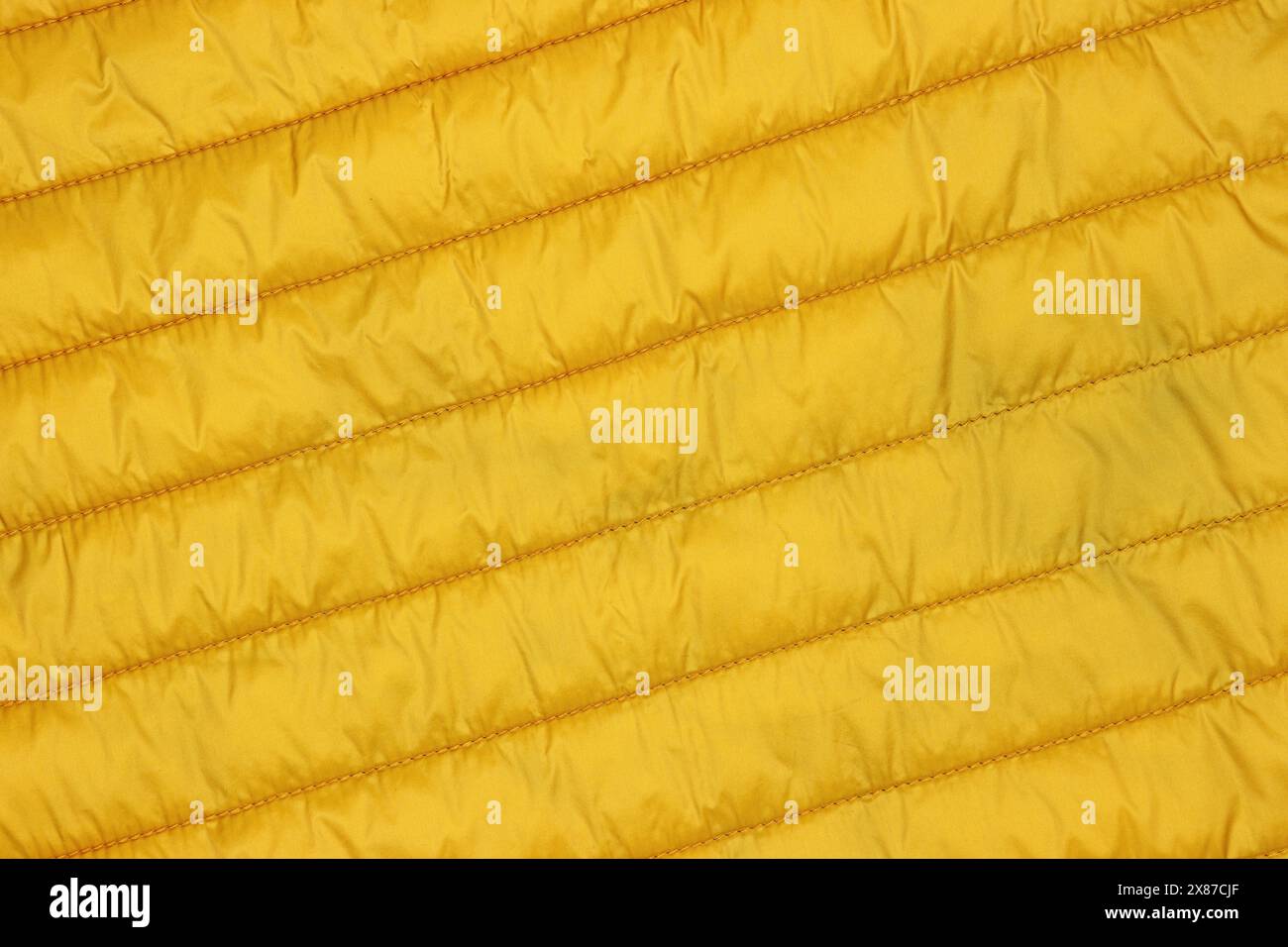 Yellow waterproof winter puffer jacket close up. Polyester fabric ...