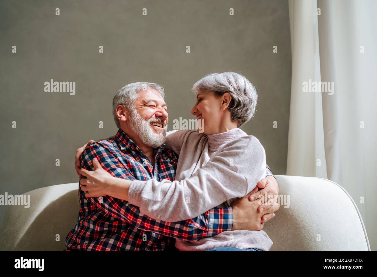 Romantic mature couple embracing on couch Stock Photo - Alamy