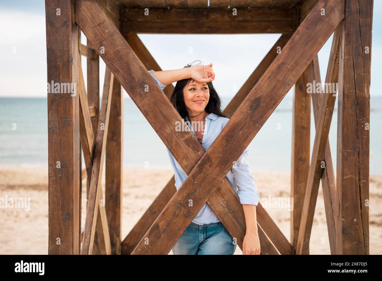 Contemplative woman standing inside lifeguard hut at beach Stock Photo ...